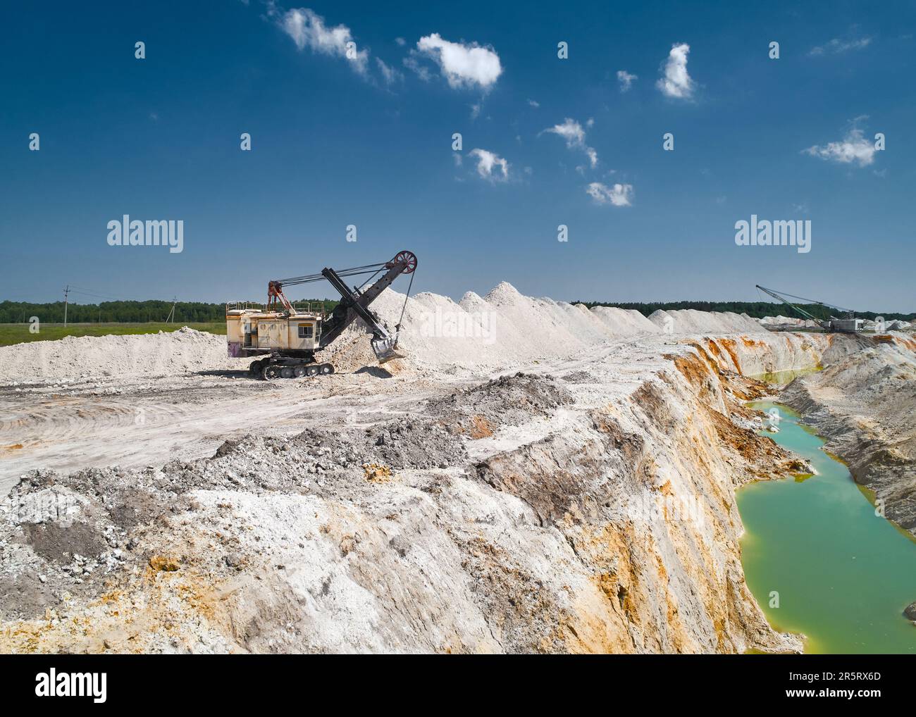 Caterpillar Shovel mining excavator near piles line in chalkquarry ...