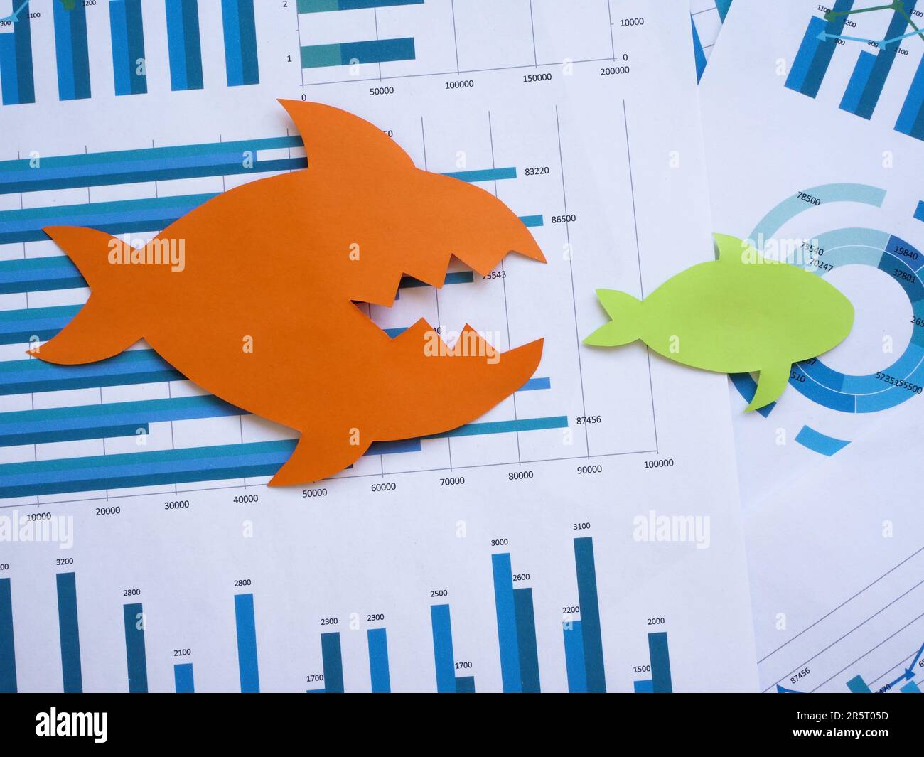 Mergers and acquisitions concept. Two paper fish lie on financial ...