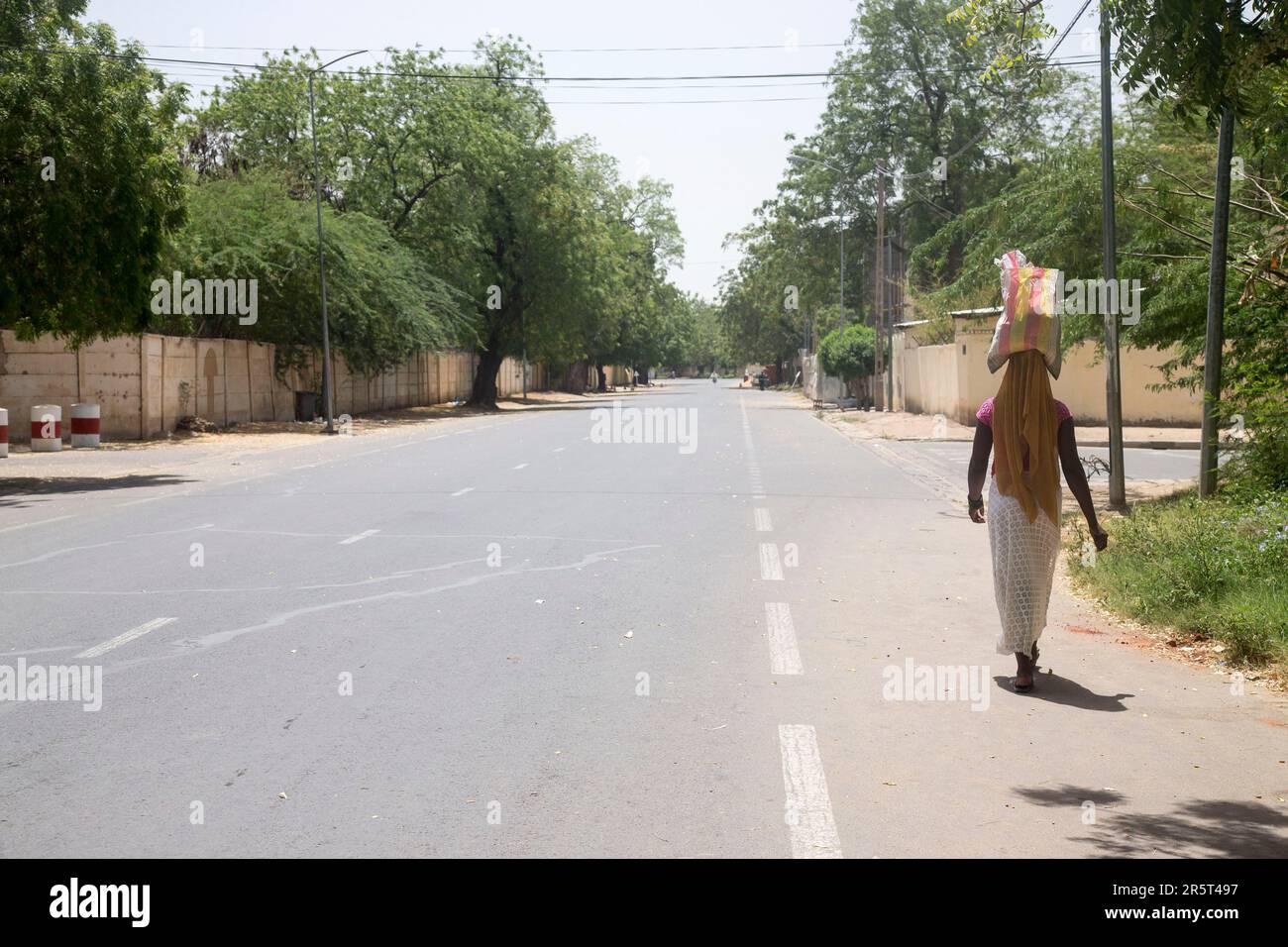 Chad, N'djamena, woman carrying her shopping on her head in a street of ...