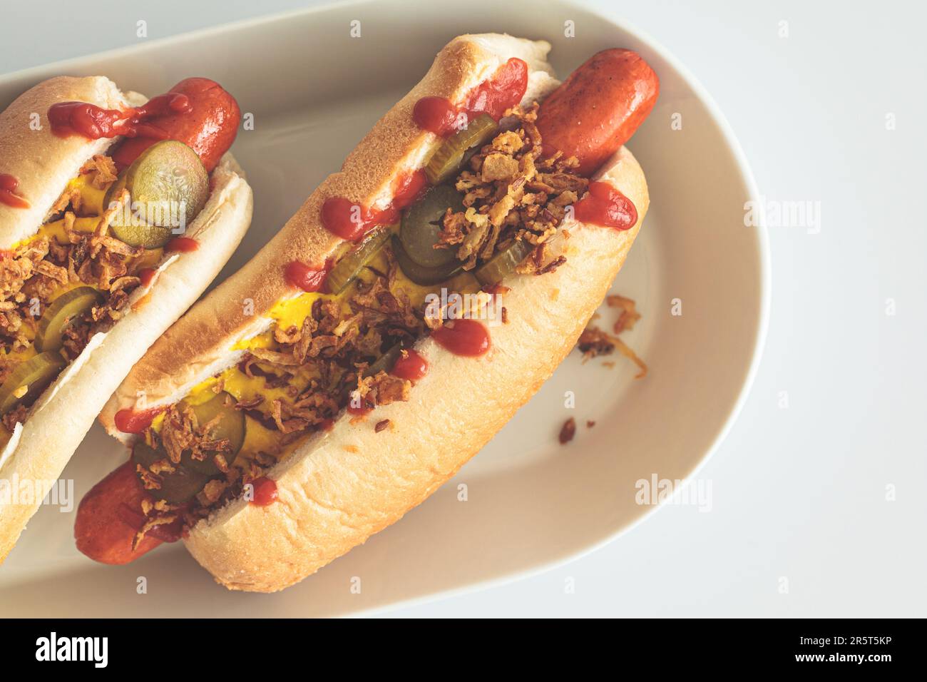 Classic hot dog with mustard, ketchup, pickles and fried onions, top ...
