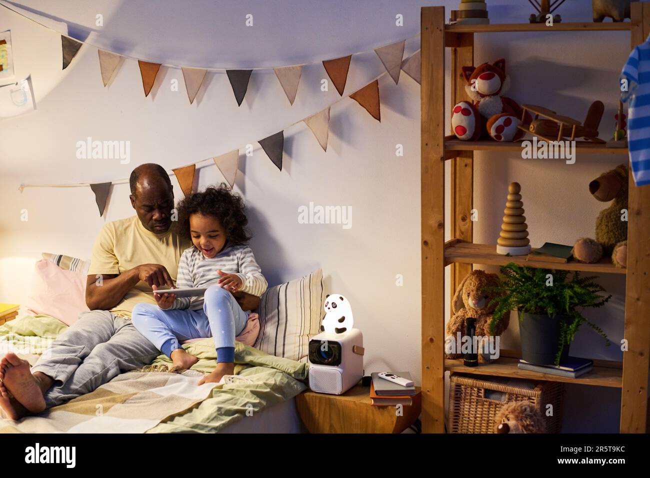 African American dad using digital tablet together with his little son ...