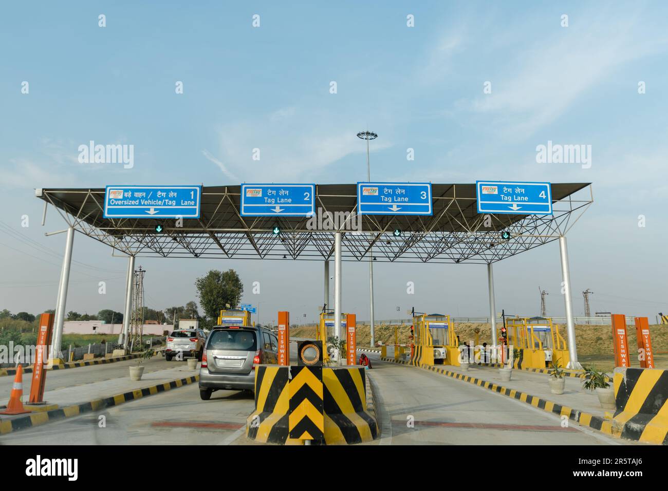 Two blue directional signs are pointing towards the entrance of a gate ...