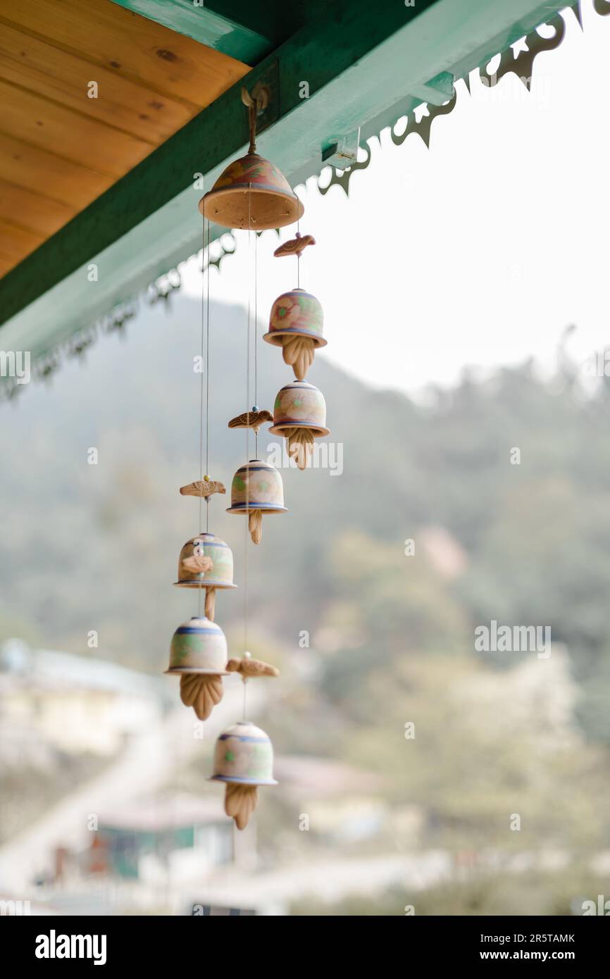 A wooden structure with several bells and hats of various colors and ...