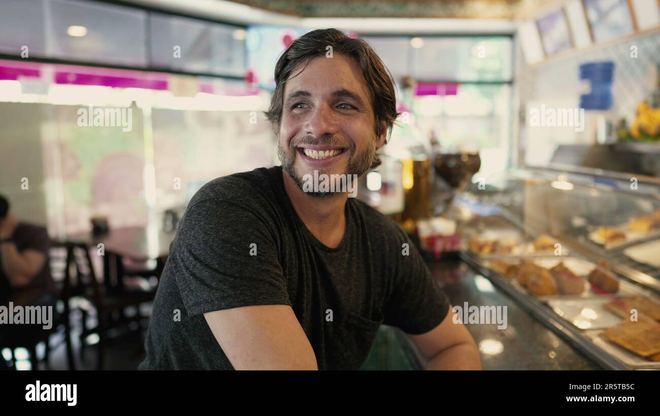 Happy man posing for camera while ordering food at restaurant diner ...