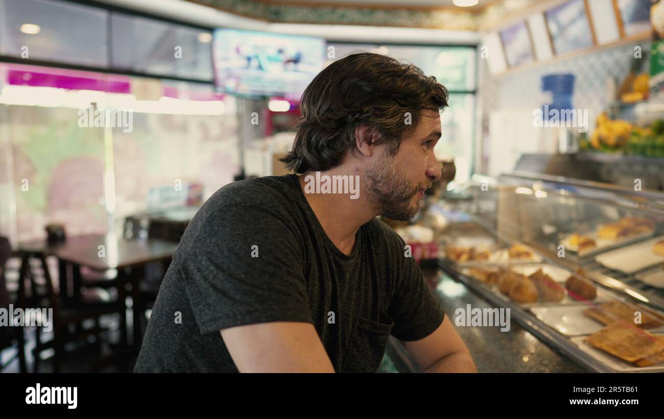 Happy man posing for camera while ordering food at restaurant diner ...