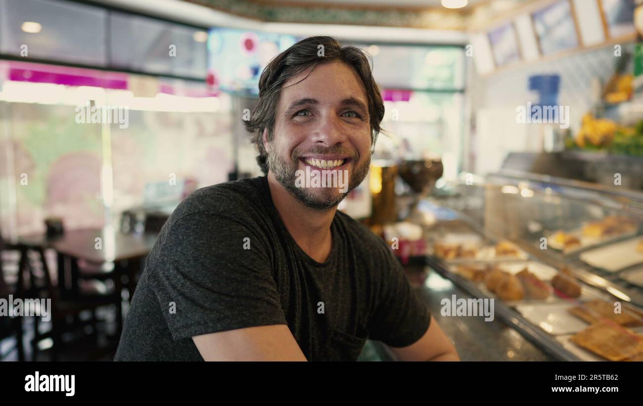 Happy man posing for camera while ordering food at restaurant diner ...