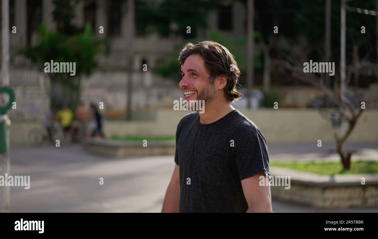 One happy handsome young man smiling and laughing while standing ...