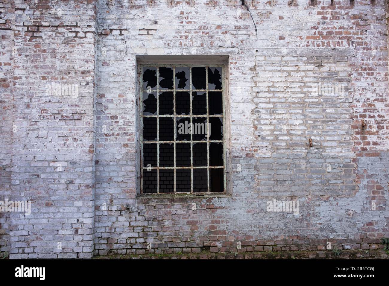 Side view of a traditional brick building with an old-fashioned barred ...