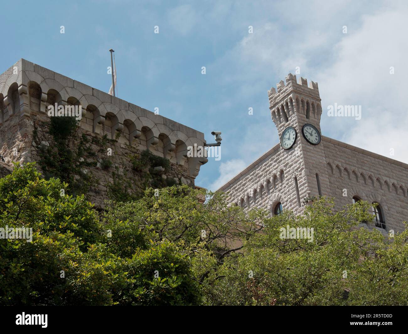 An ancient clock tower stands proudly against a bright blue sky, a ...