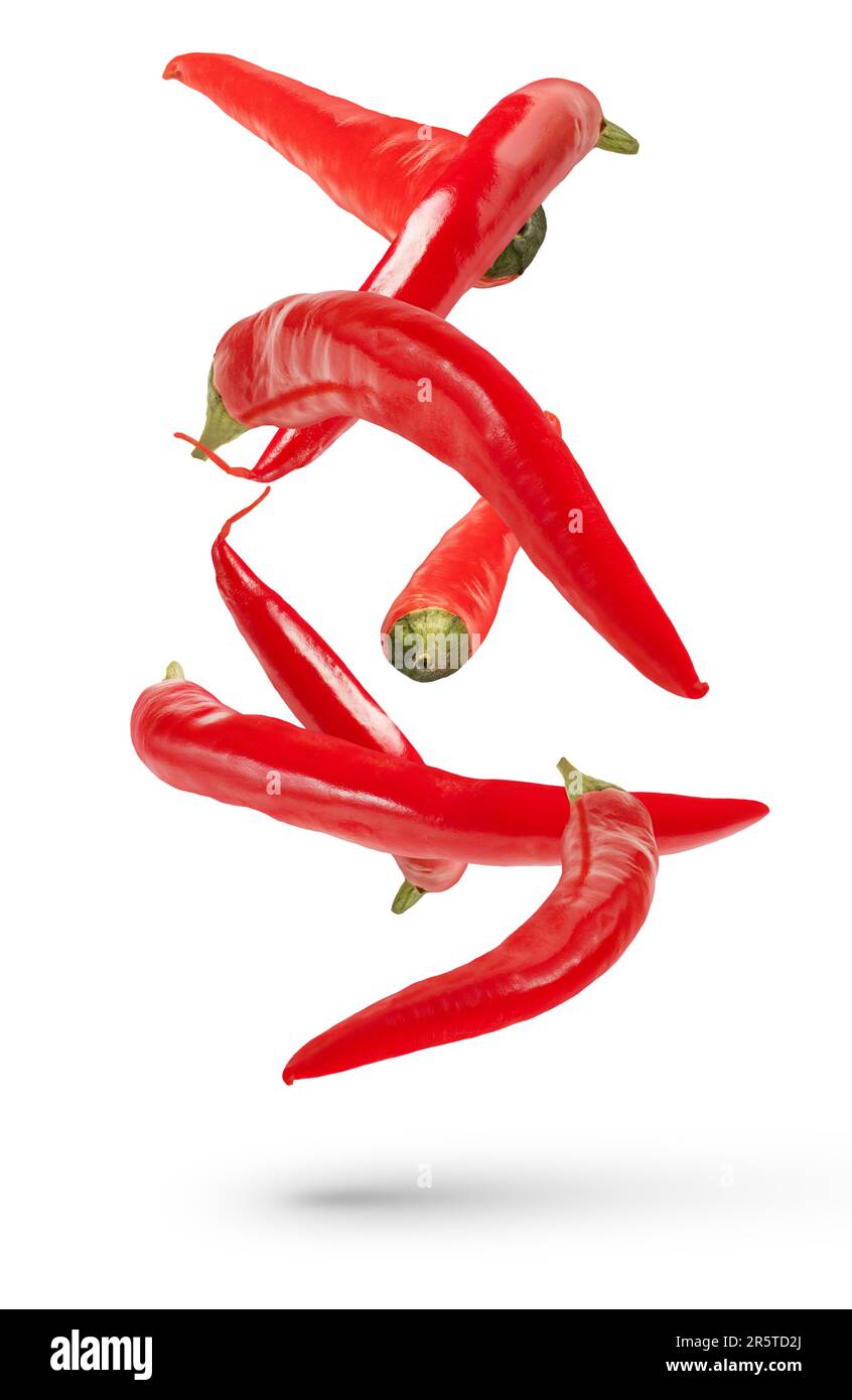 Pods of red hot peppers of various sizes and shapes fall on a white ...