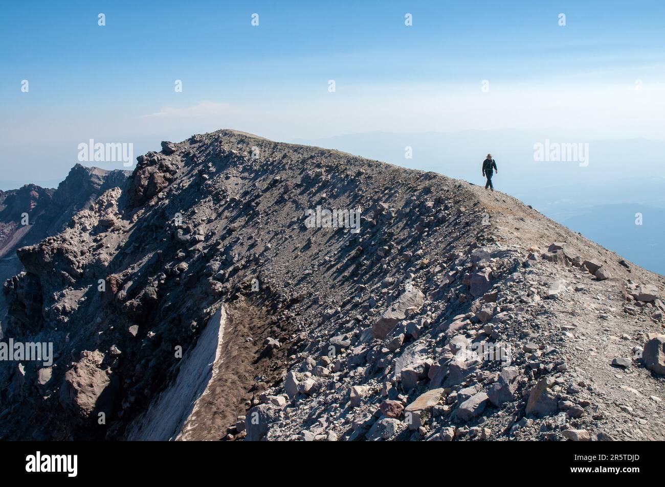 Climber hiking the rim nearing the summit of Mt Saint Helen, Washington ...