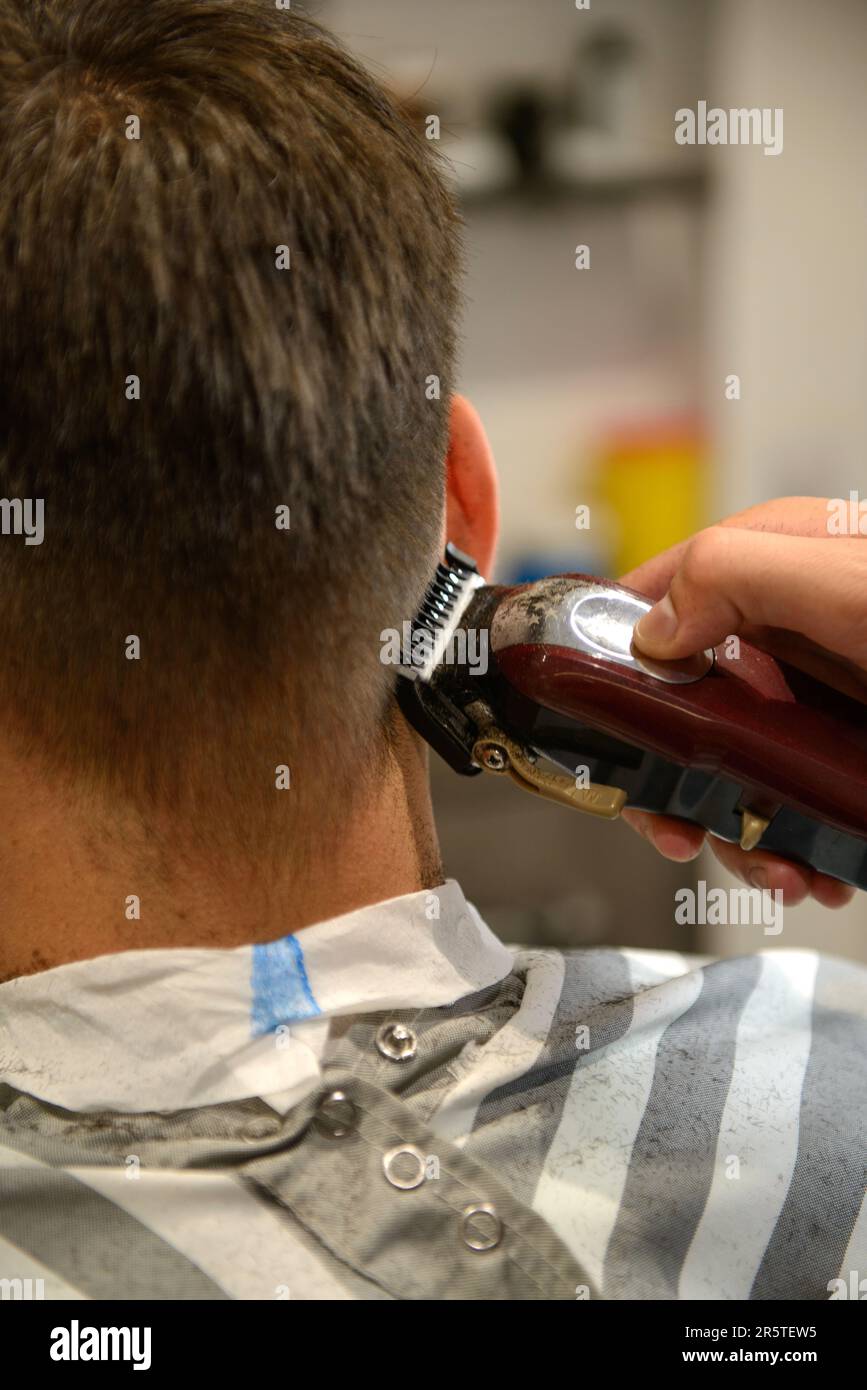 Man getting a haircut with an electric shaver at the barber Stock Photo ...