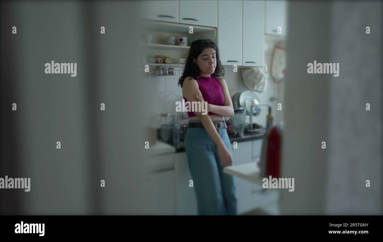 One pensive young woman thinking about life standing in kitchen ...