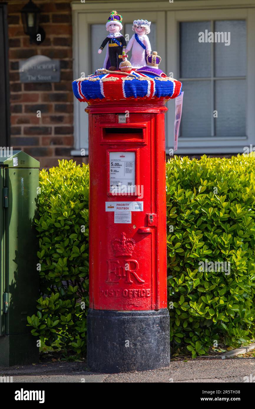 Sussex, UK - April 30th 2023: A knitted Post Box Topper on a red post ...