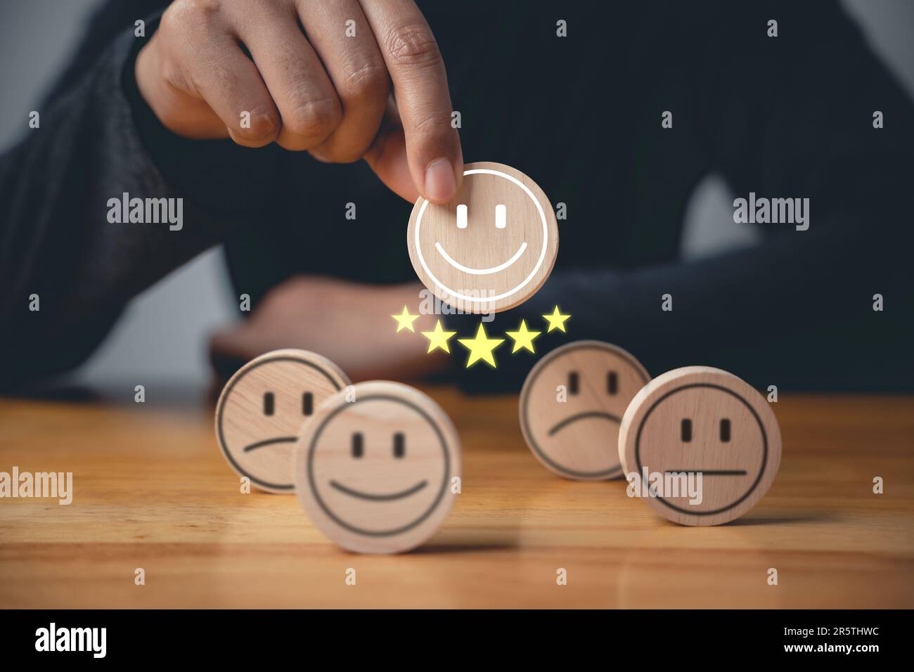 Selecting a smiley face on a wooden block circle Stock Photo - Alamy