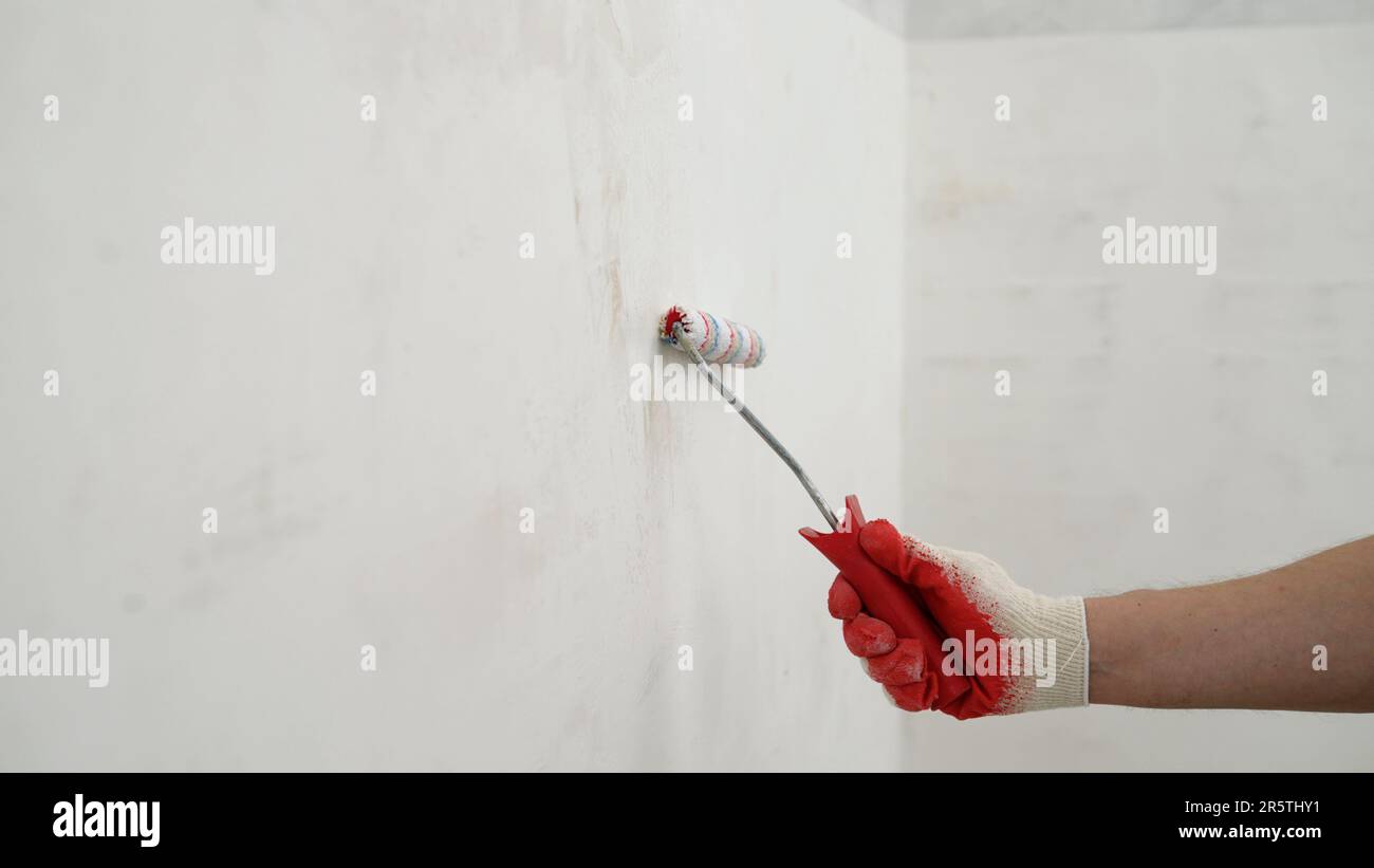 Wall primer. Applying a primer to the wall before gluing the tiles ...
