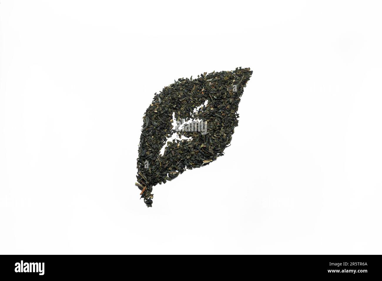 Dried tea arranged in a tea leaves shape close-up with white background ...