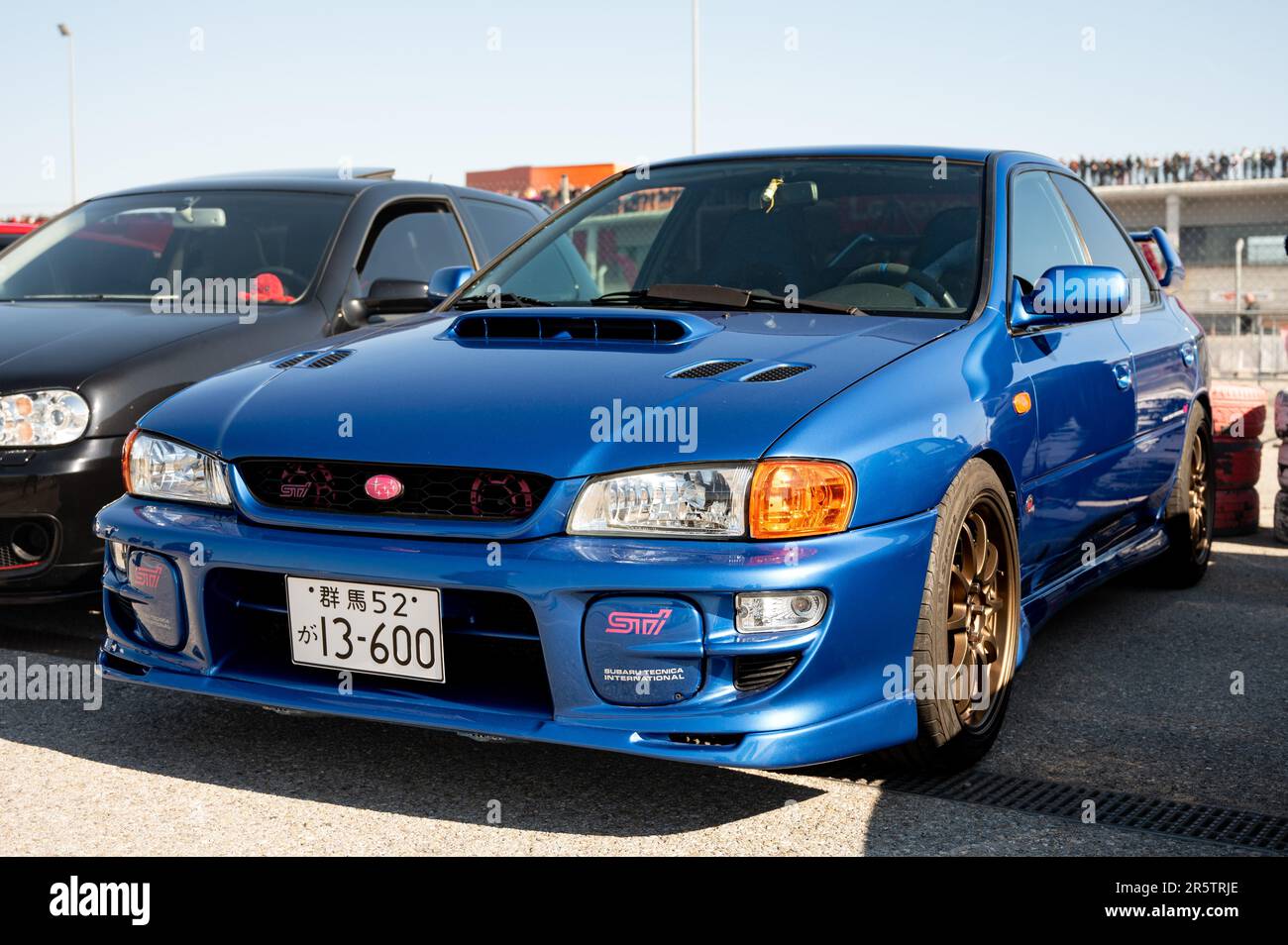 A detail of a blue first generation Subaru Impreza parked on the street ...