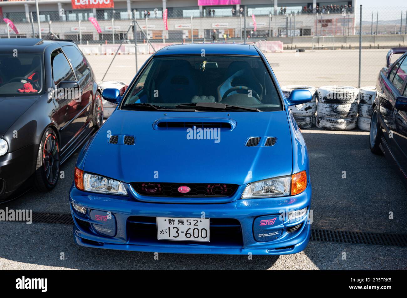 A detail of a blue first generation Subaru Impreza parked on the street ...