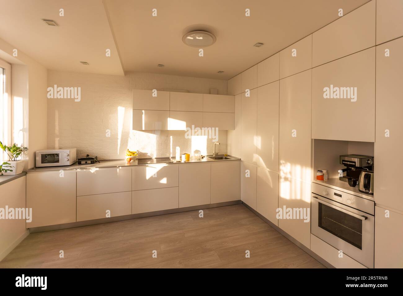 Modern white kitchen sink with morning sun rays Stock Photo - Alamy