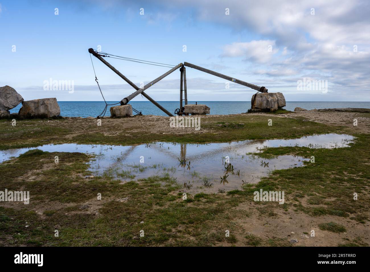 A traditional quarry crane stands beside the Jurassic Coast path on ...
