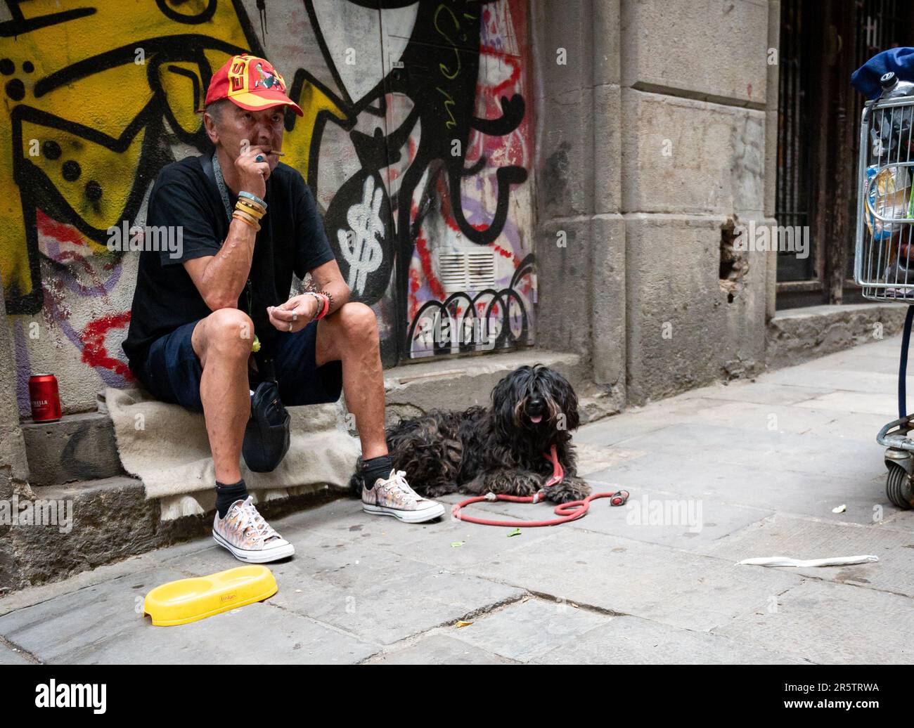 A drunk homeless beggar in the street of the city of Barcelona, Spain ...