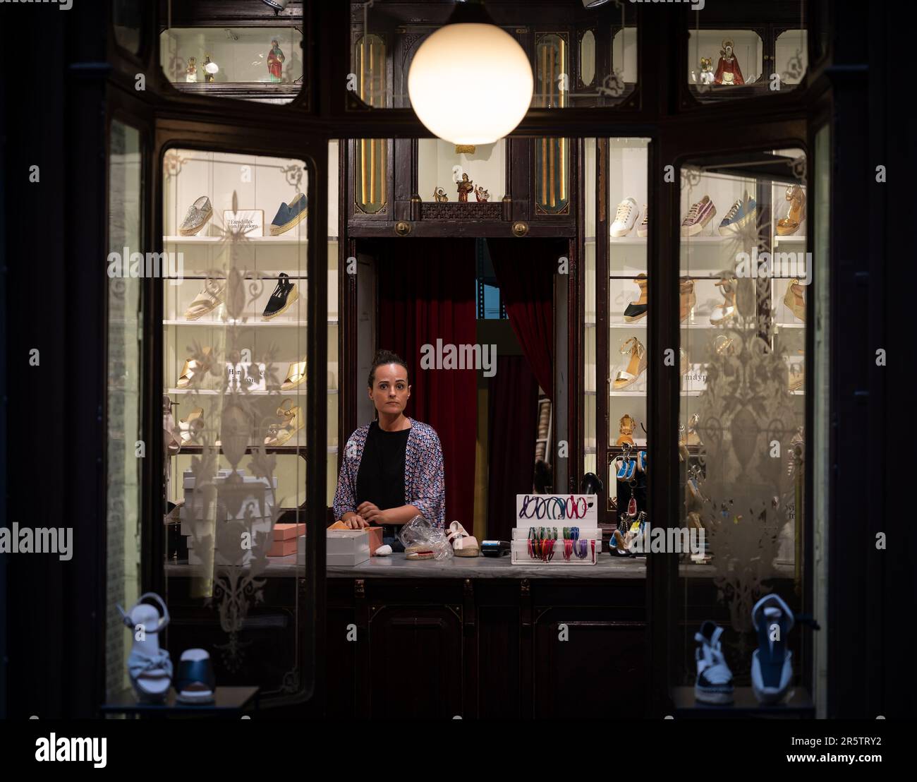 A pretty shop assistant seen through a window in the city of Barcelona ...