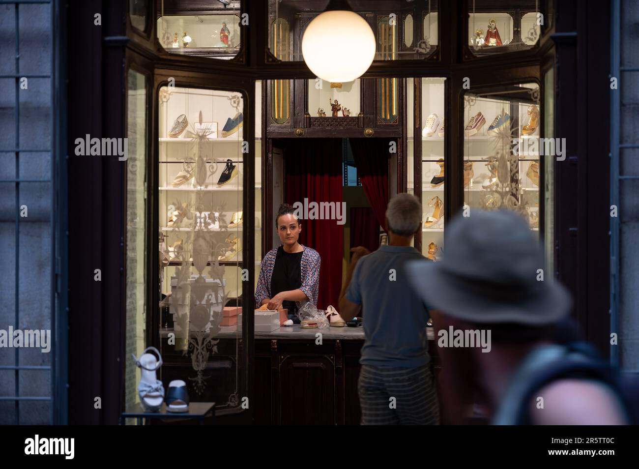 A pretty shop assistant seen through a window in the city of Barcelona ...
