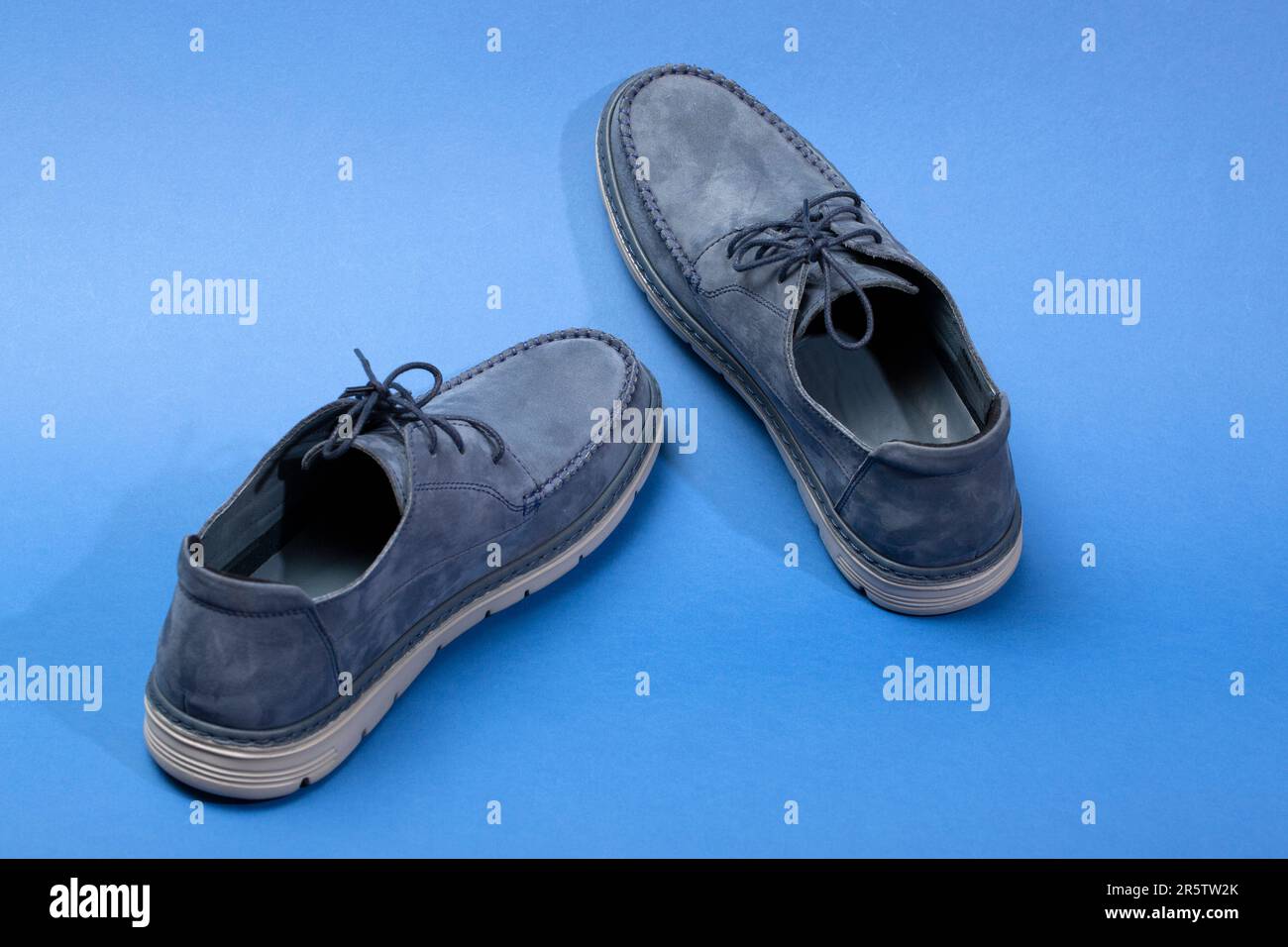 Blue leather men's shoes on a blue background Stock Photo - Alamy