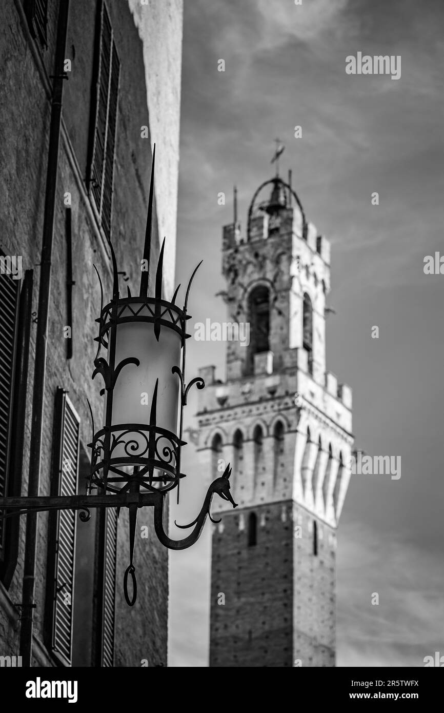 Beautifully decorated street lamp with blurred tower of Siena city in ...