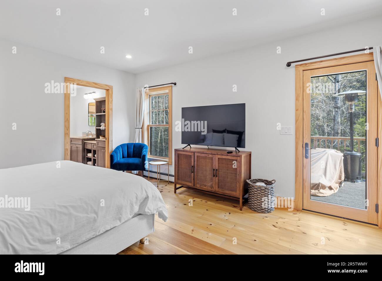 An interior view of a modern bedroom with a large bed and flat screen ...