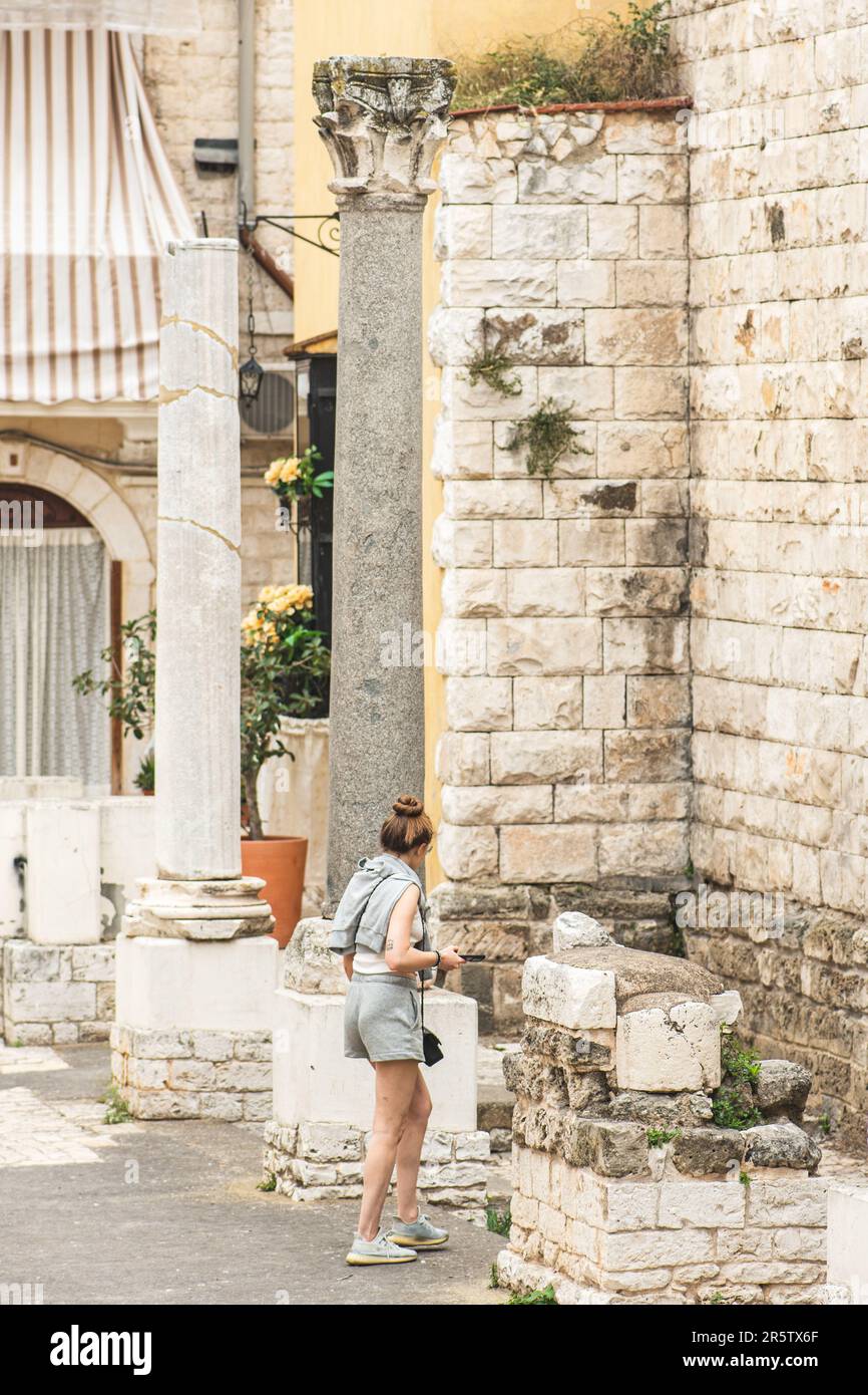 Beautiful girl walking among the remains and columns of a Roman Temple ...