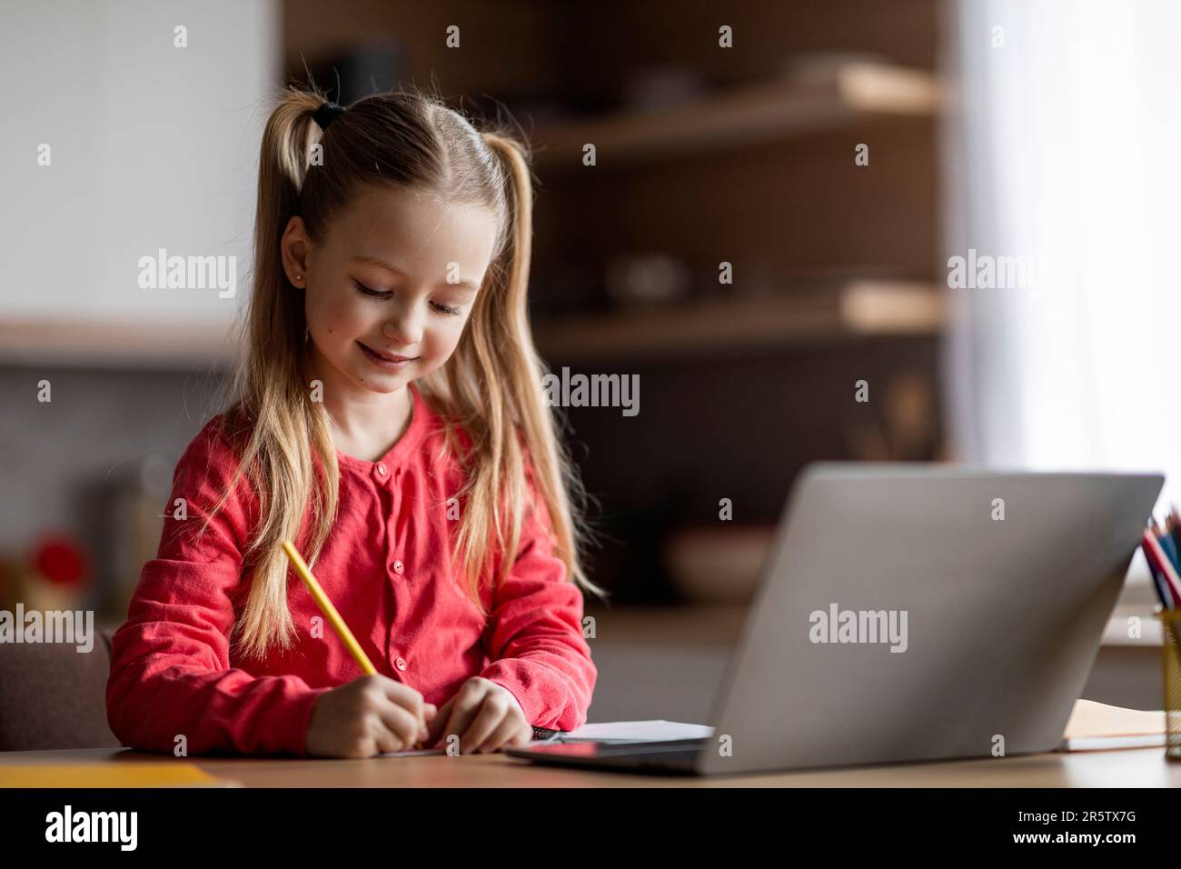 Adorable Little Girl Writing Notes While Study With Laptop At Home ...