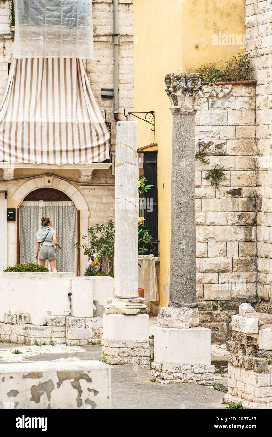 Beautiful girl walking among the remains and columns of a Roman Temple ...