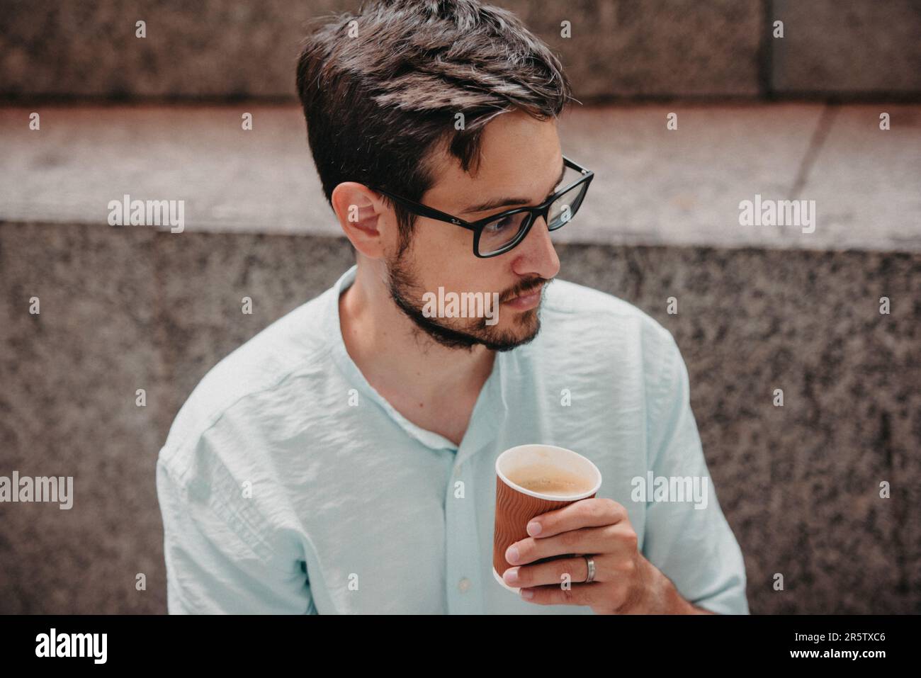 Serious young man with a blank stare about to drink a coffee Stock ...