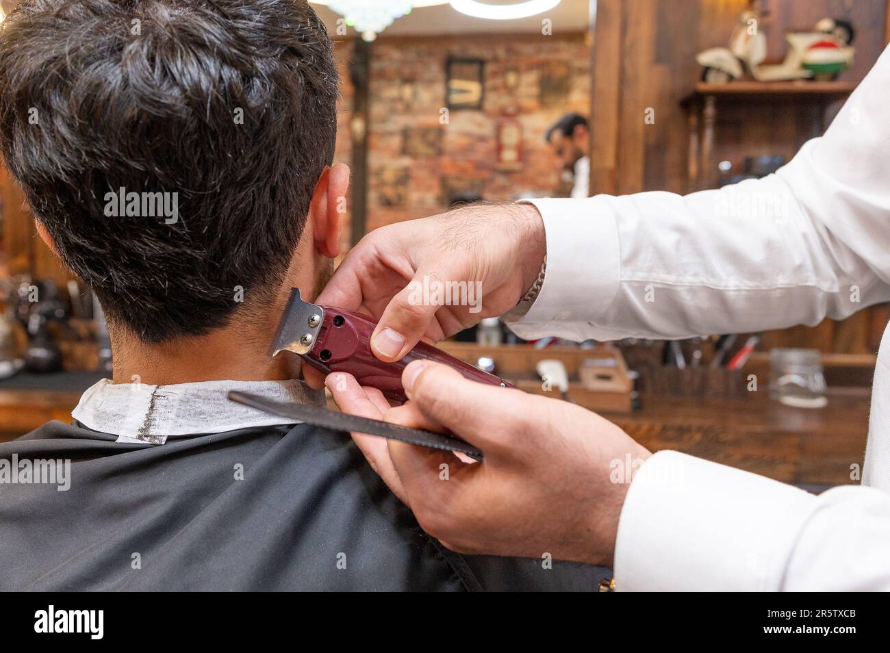 A close up of a barber cutting a man's hair in a barbershop Stock Photo ...