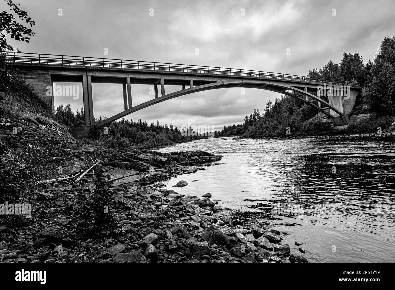 An aerial gray scale view of a long bridge spanning a river in ...
