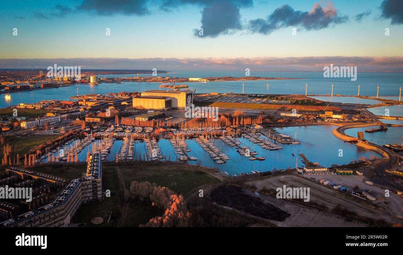 A scenic marina is depicted, with a body of water in the foreground and ...