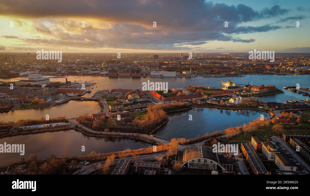 Aerial view of a cityscape featuring a river with a variety of ...