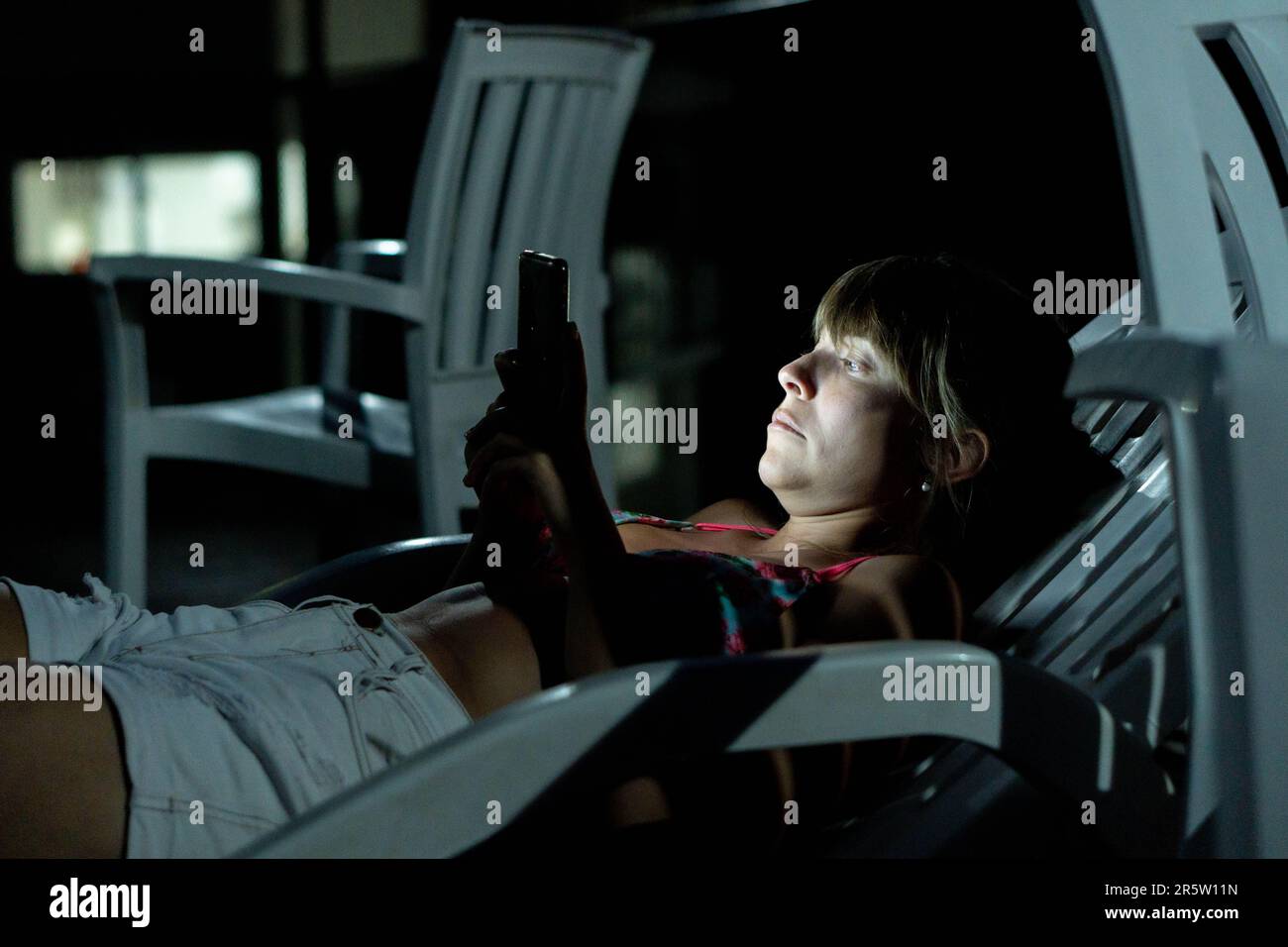 A cheerful young female in a comfortable position, lying on her stomach ...