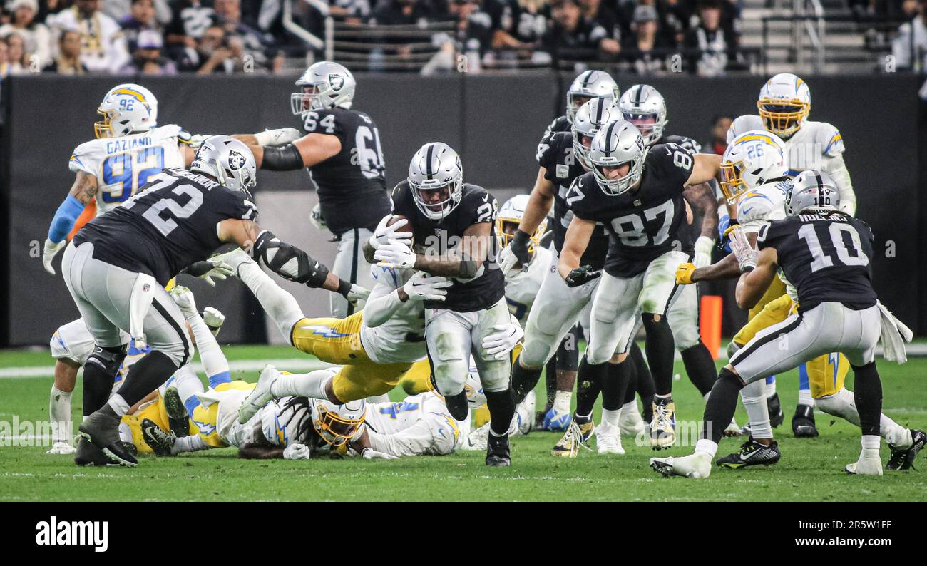 A group of football players engaged in a match on a well-lit football ...