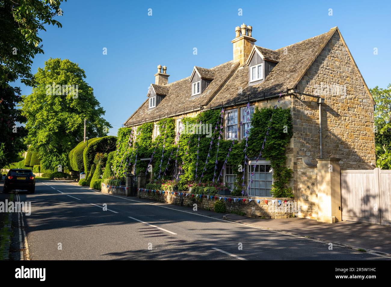 Traditional Cotswold stone cottages are decorated with bunting and half ...