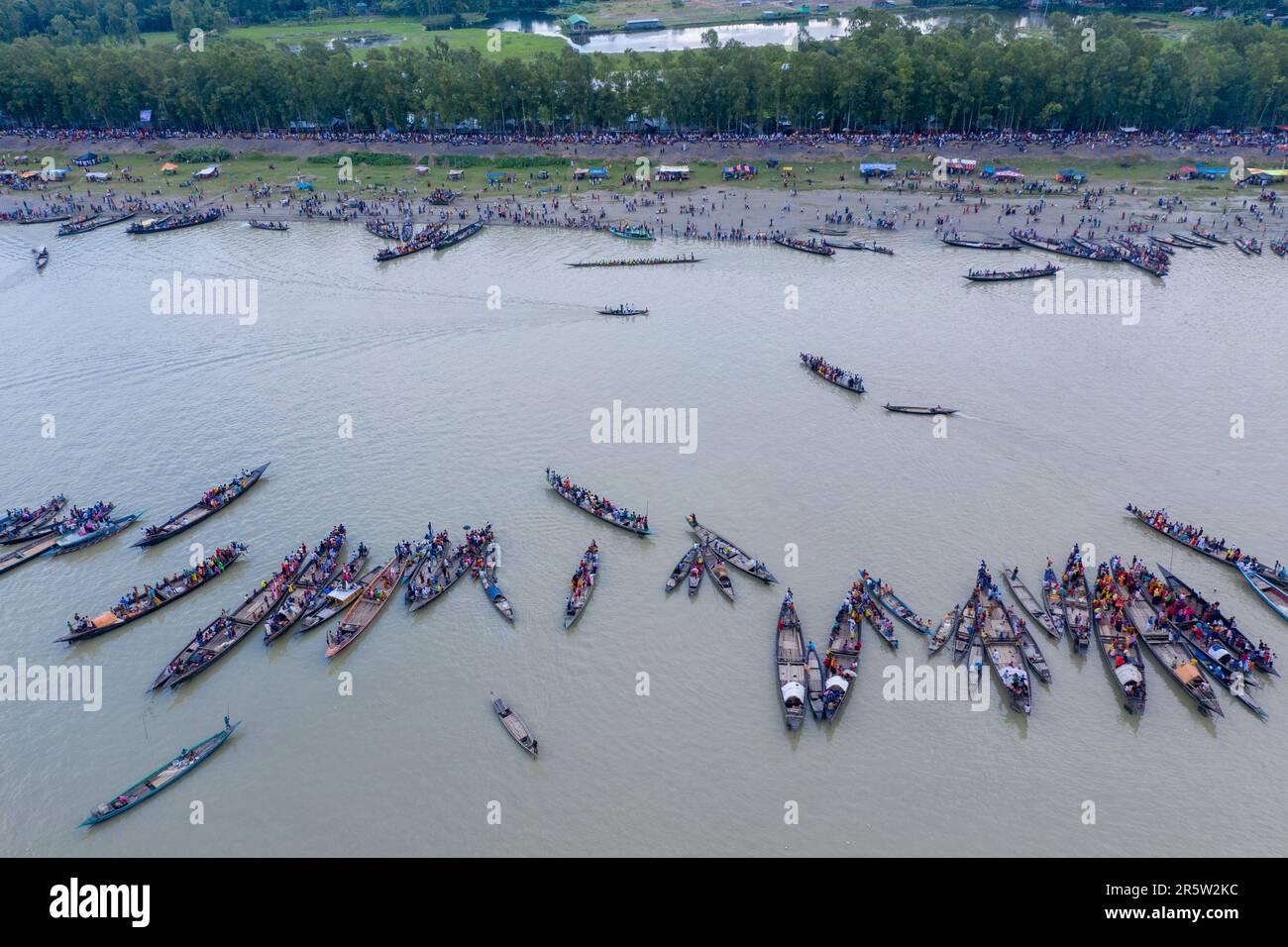 Spectators enjoying a traditional boat race on the Jamuna River ...