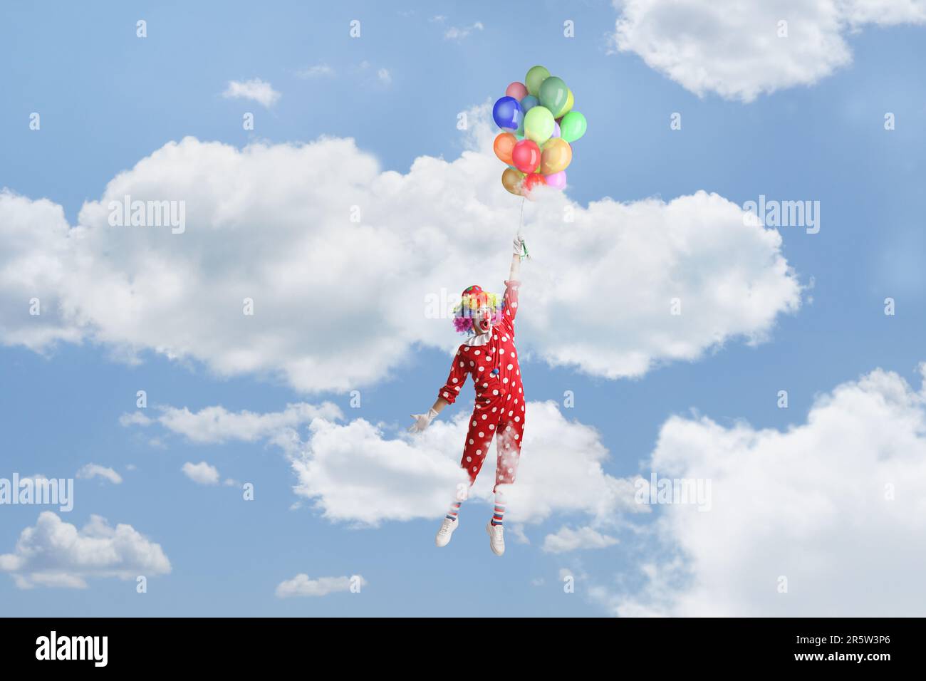 Funny clown holding a bunch of balloons and flying up in the sky Stock ...