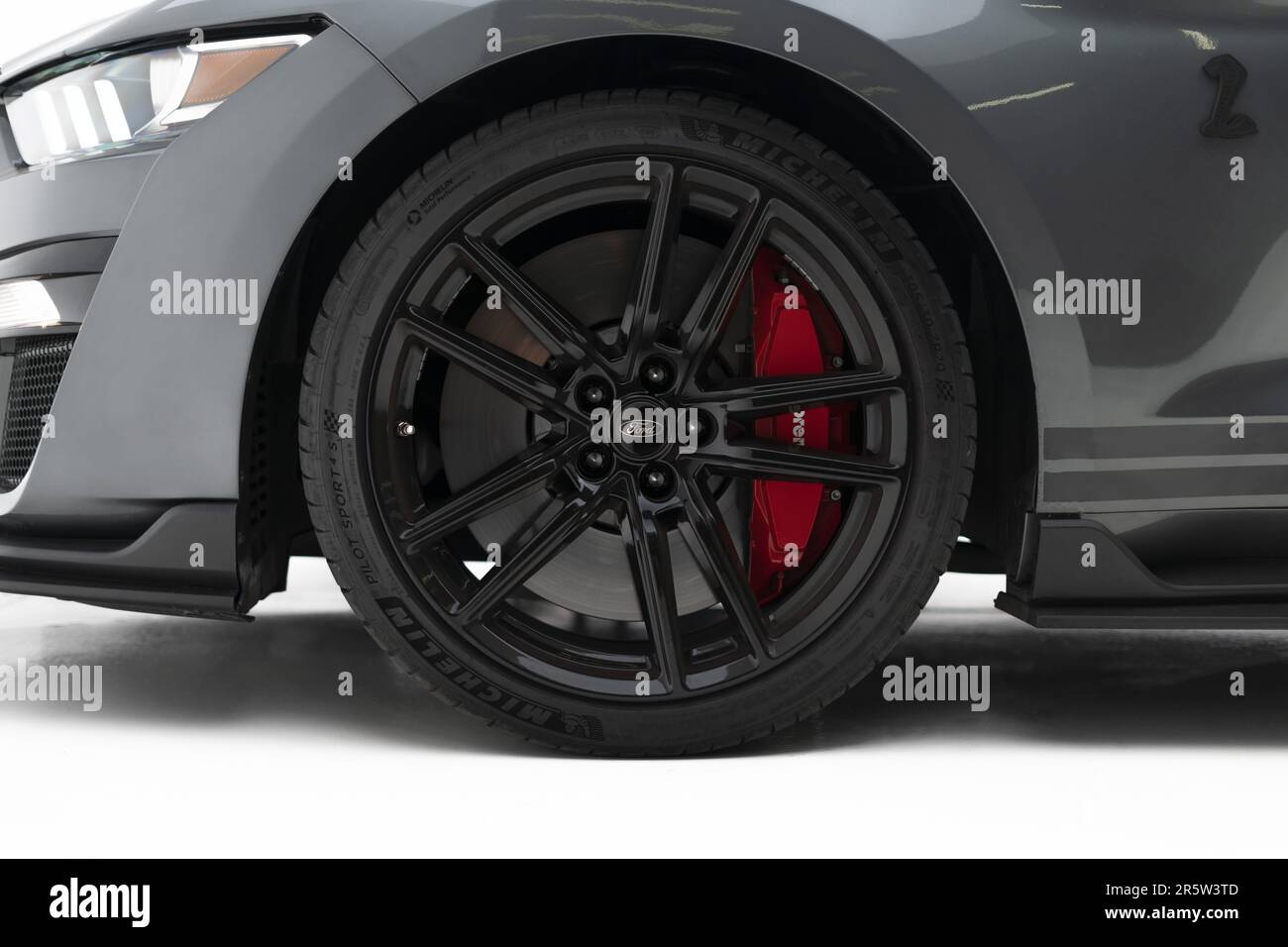 A black sports car with vibrant red-spoked front wheels and tires Stock ...