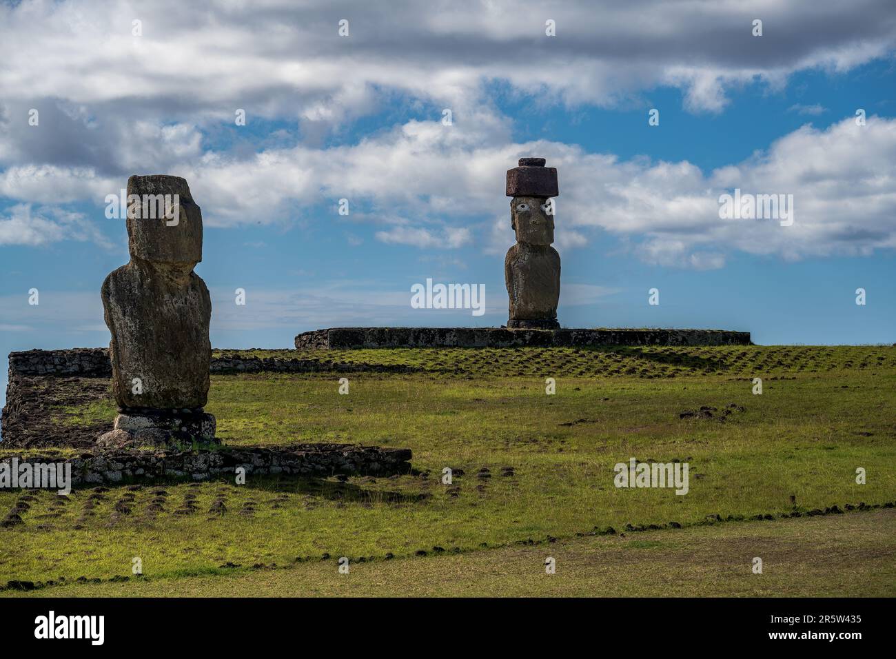 A photo of two Moai statues facing inward on Easter Island, one with ...