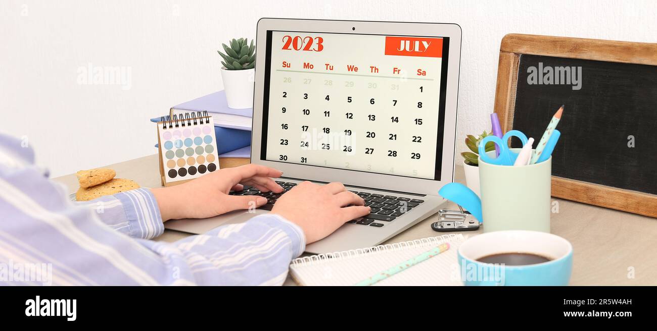 Businesswoman with laptop using calendar application in office Stock ...