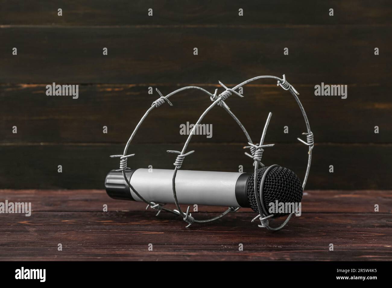 Microphone with barbed wire on dark wooden background. Censorship ...