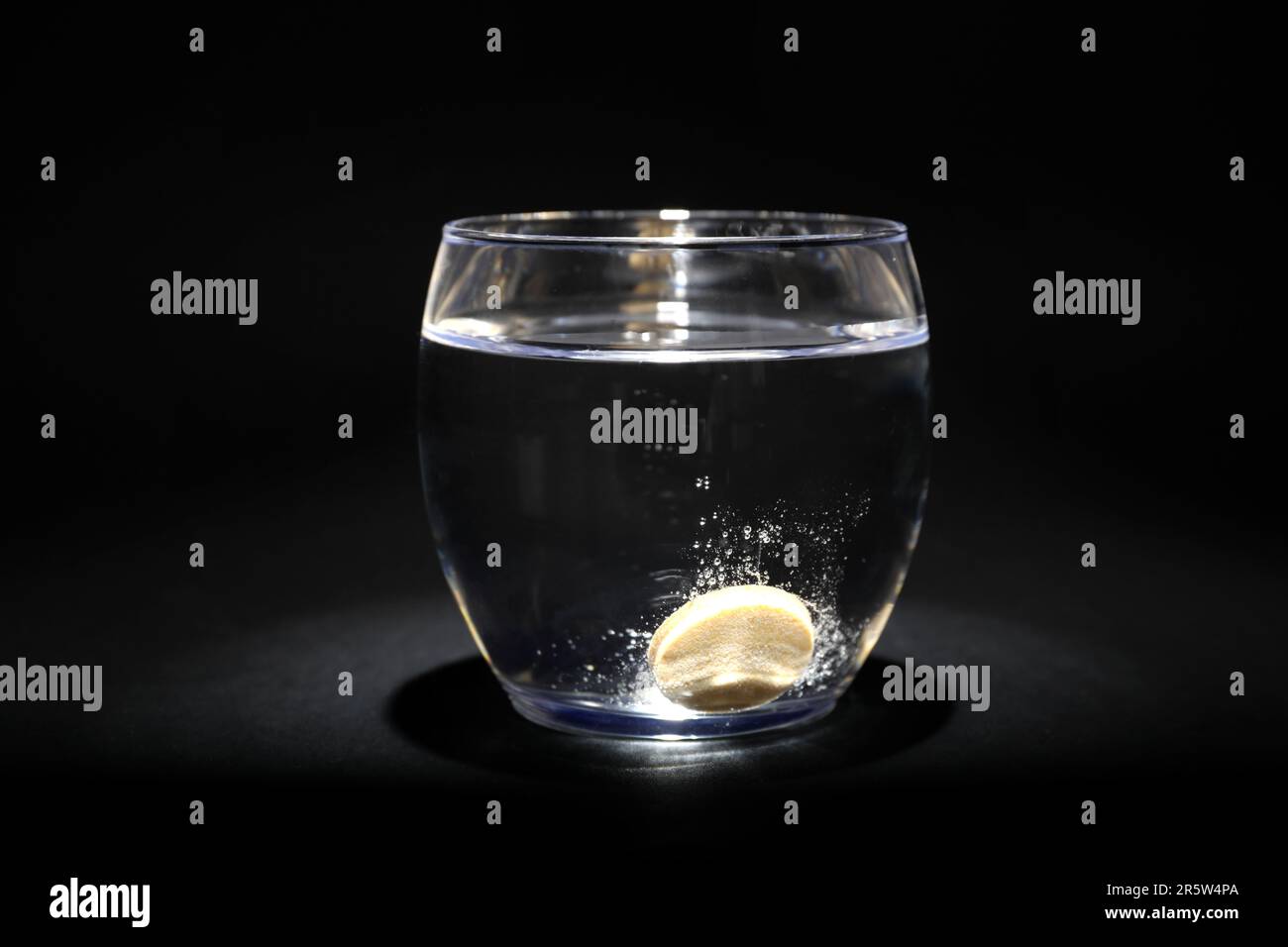 Glass of water with soluble tablet on black background Stock Photo - Alamy