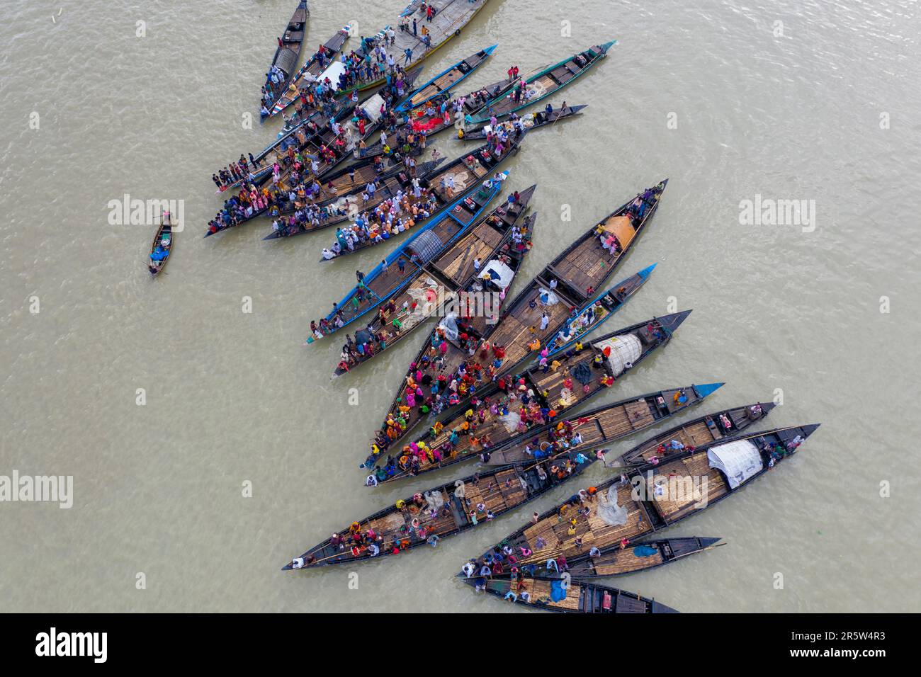 Spectators enjoying a traditional boat race on the Jamuna River ...